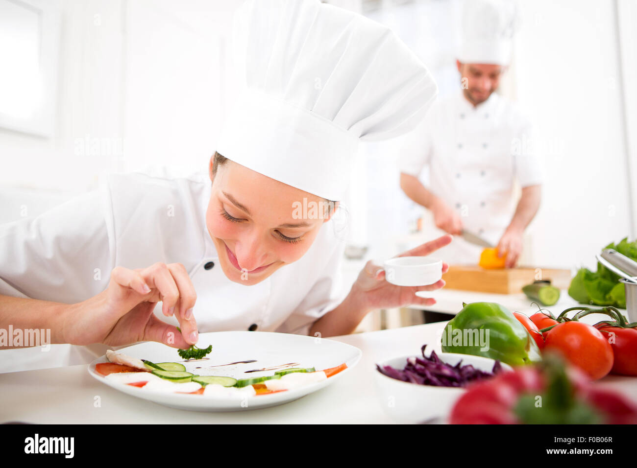 View of a Young attractive professional chef cooking in his kitchen ...