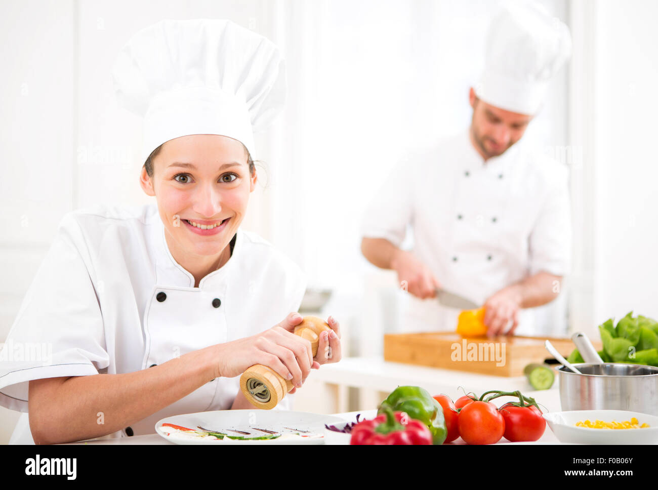 View of a Young attractive professional chef cooking in his kitchen ...