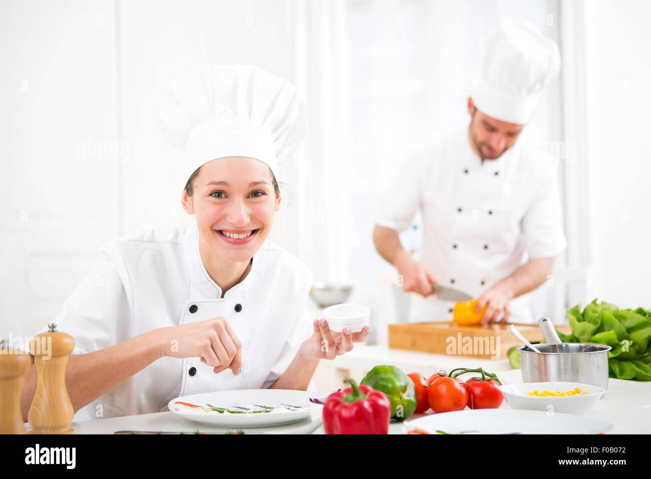 View of a Young attractive professional chef cooking in his kitchen ...
