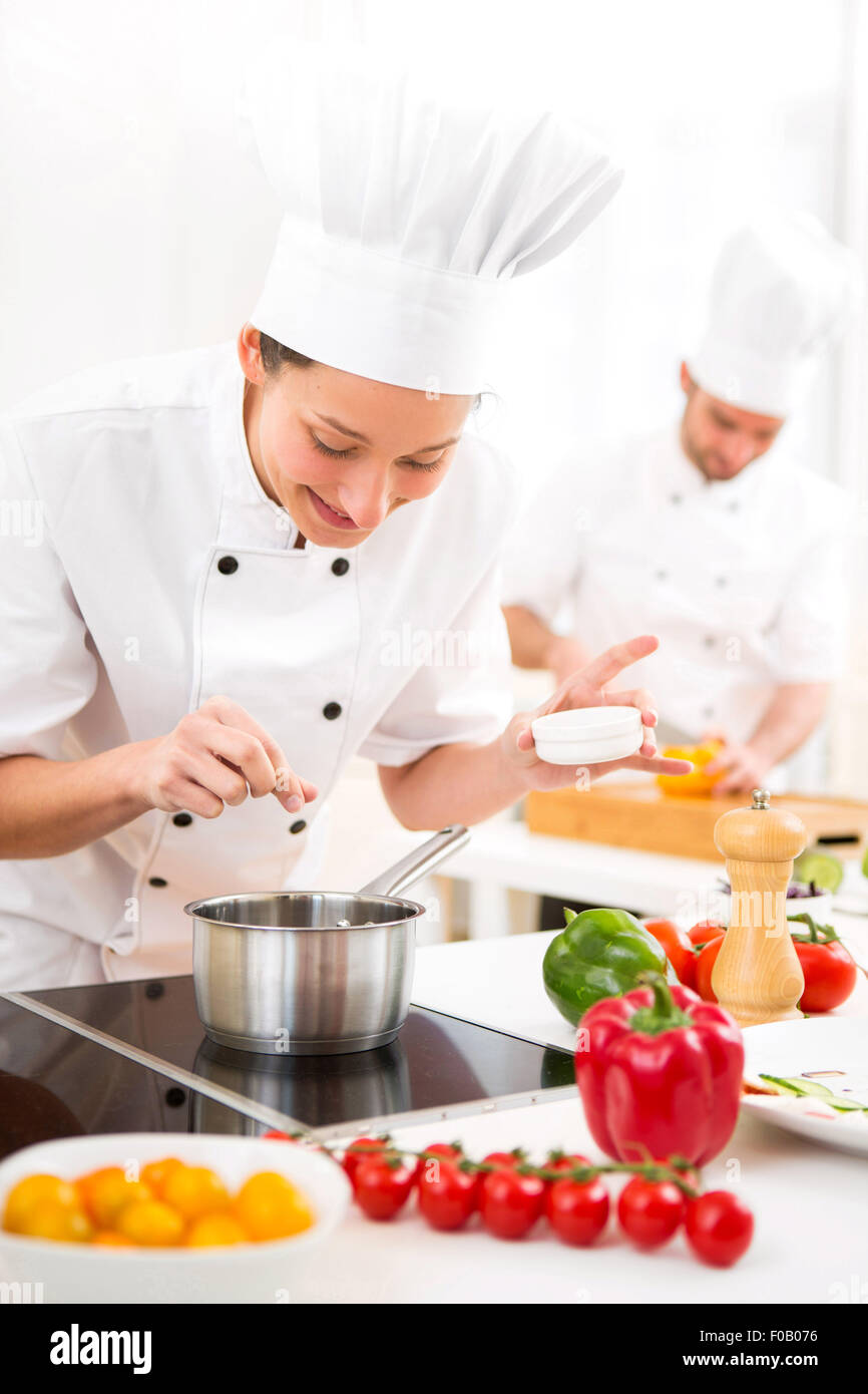View of a Young attractive professional chef cooking in his kitchen ...