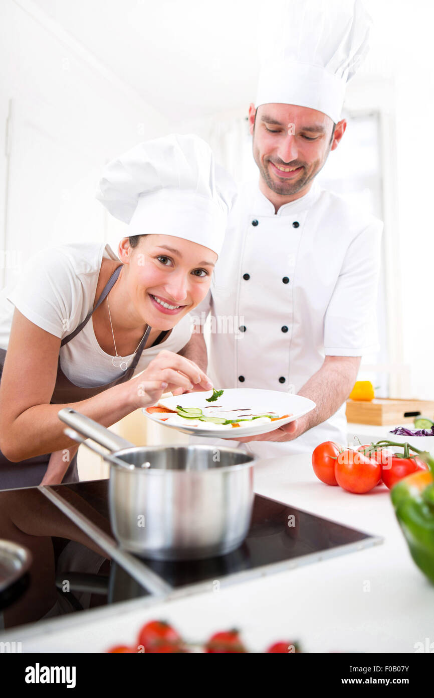 View of a Young chef training a young attractive girl to cook Stock ...