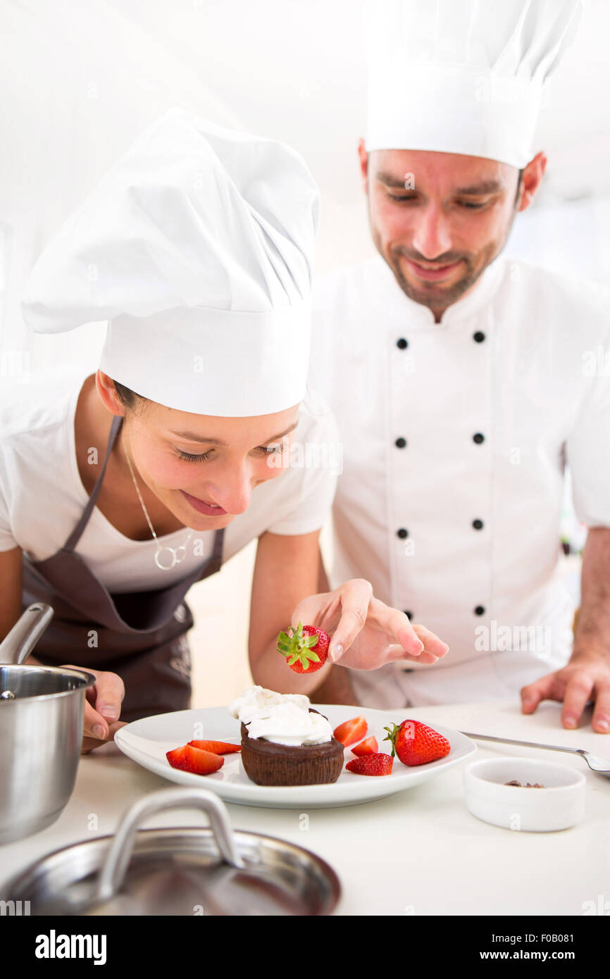 View of a Young chef training a young attractive girl to cook Stock ...