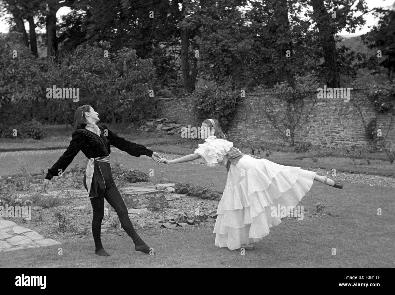 Two young women dancing in a garden Stock Photo - Alamy
