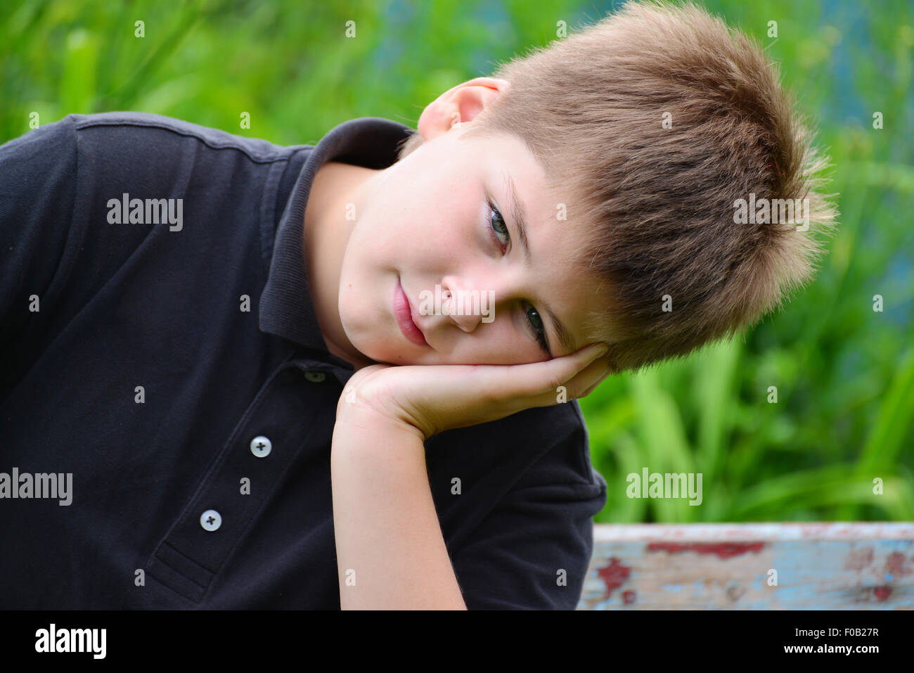 A Teenage boy sitting on a bench Stock Photo - Alamy