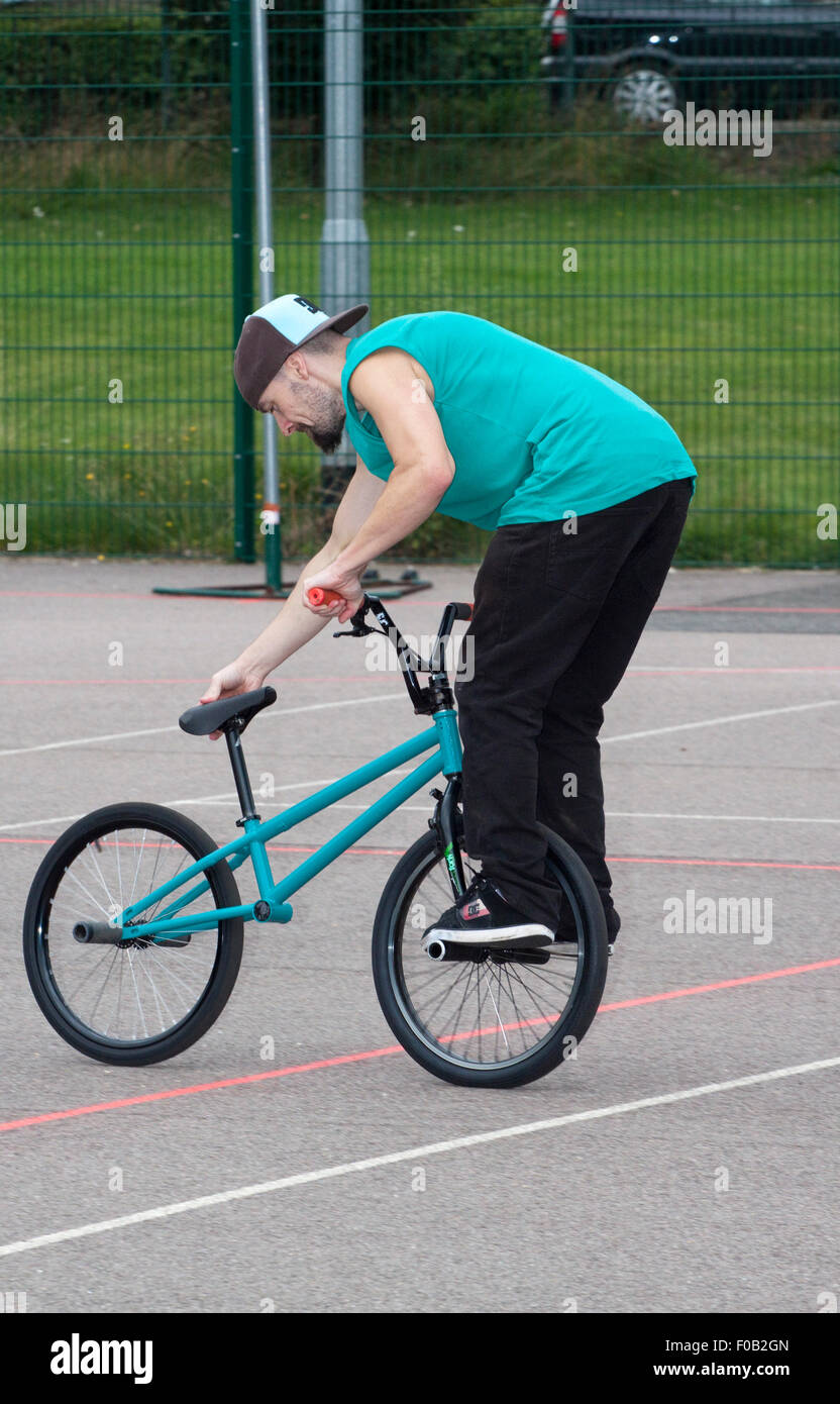 A slightly older young man performing tricks and stunts on a BMX type ...