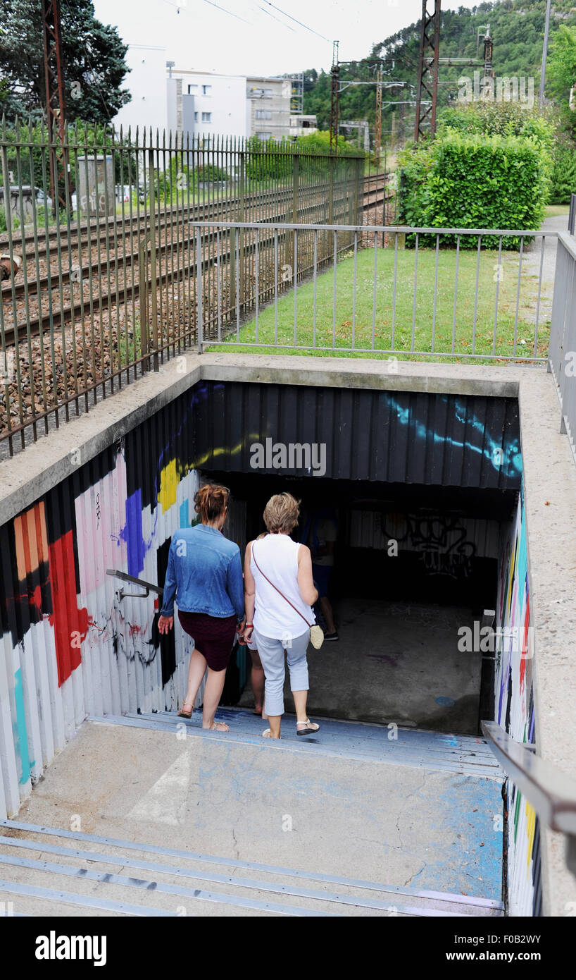 Female tourists walk through an underpass to cross railway tracks at ...