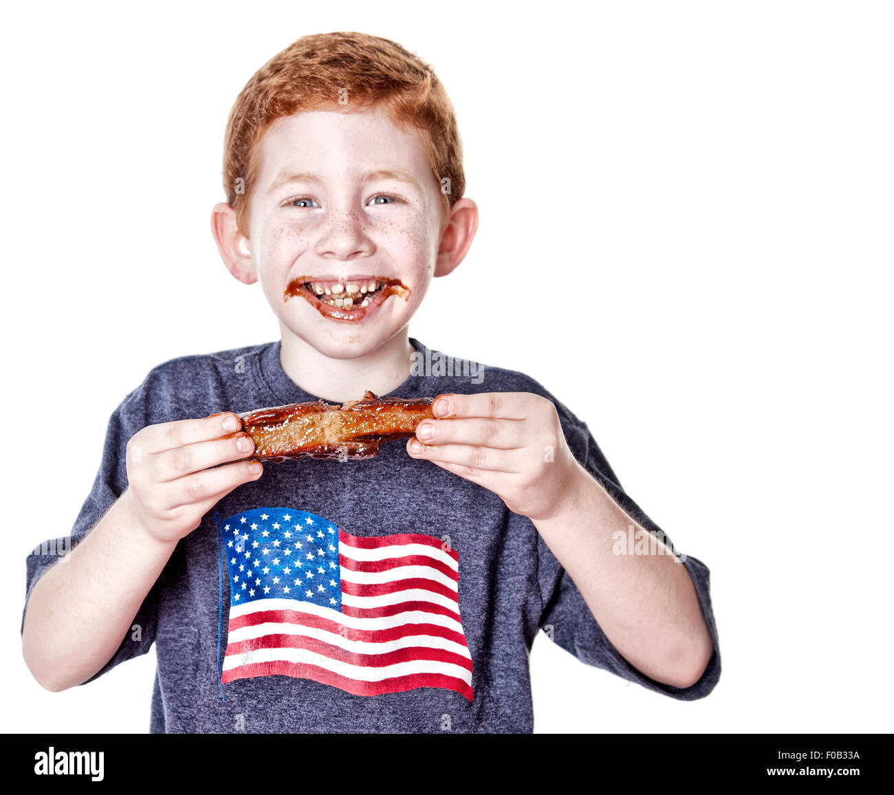 Hungry boy eating BBQ rib in studio Stock Photo - Alamy