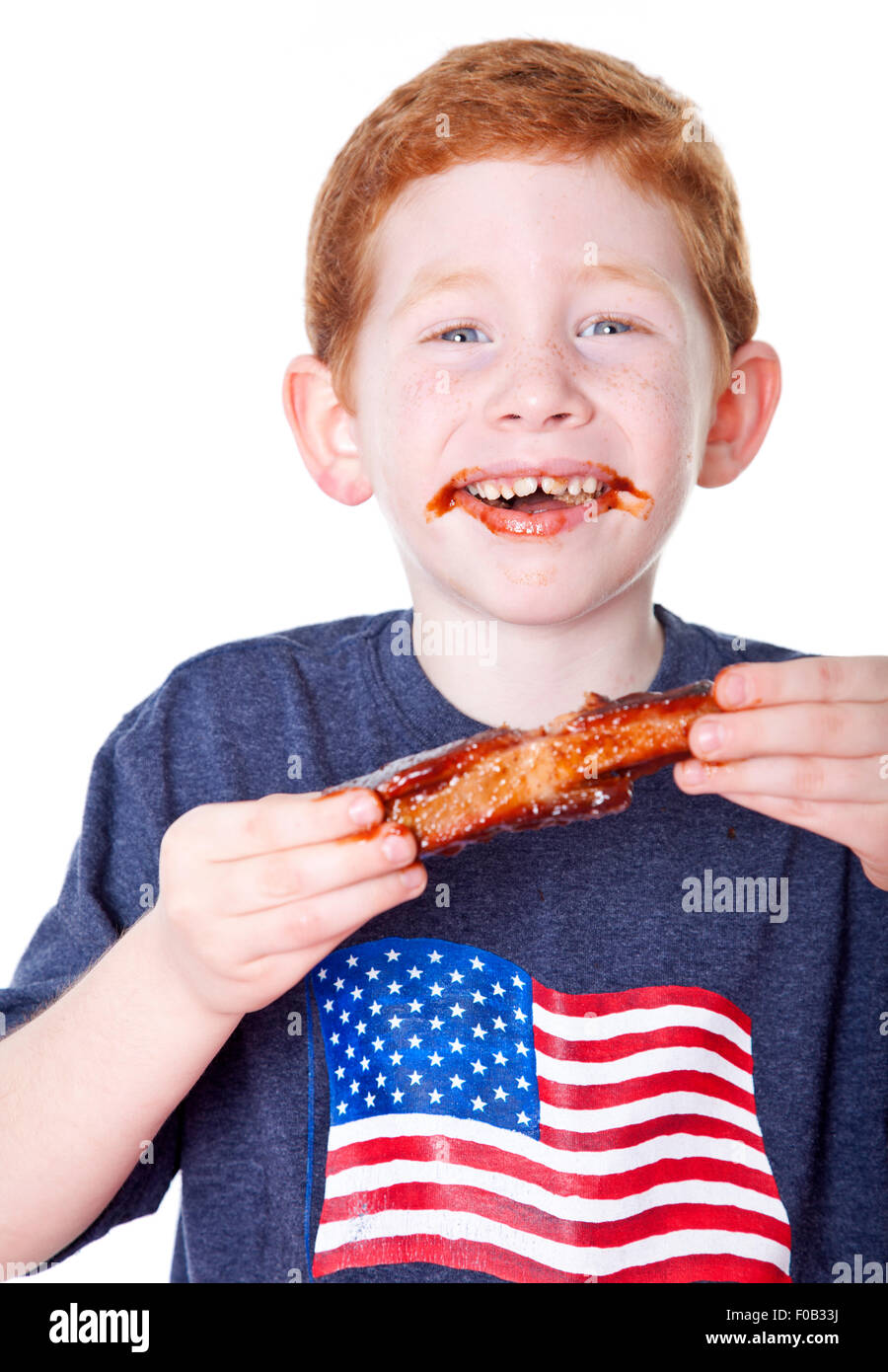 Hungry boy eating BBQ rib in studio Stock Photo - Alamy