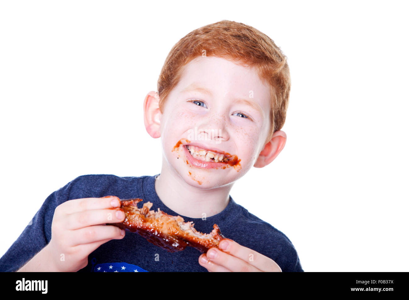 Hungry boy eating BBQ rib in studio Stock Photo - Alamy