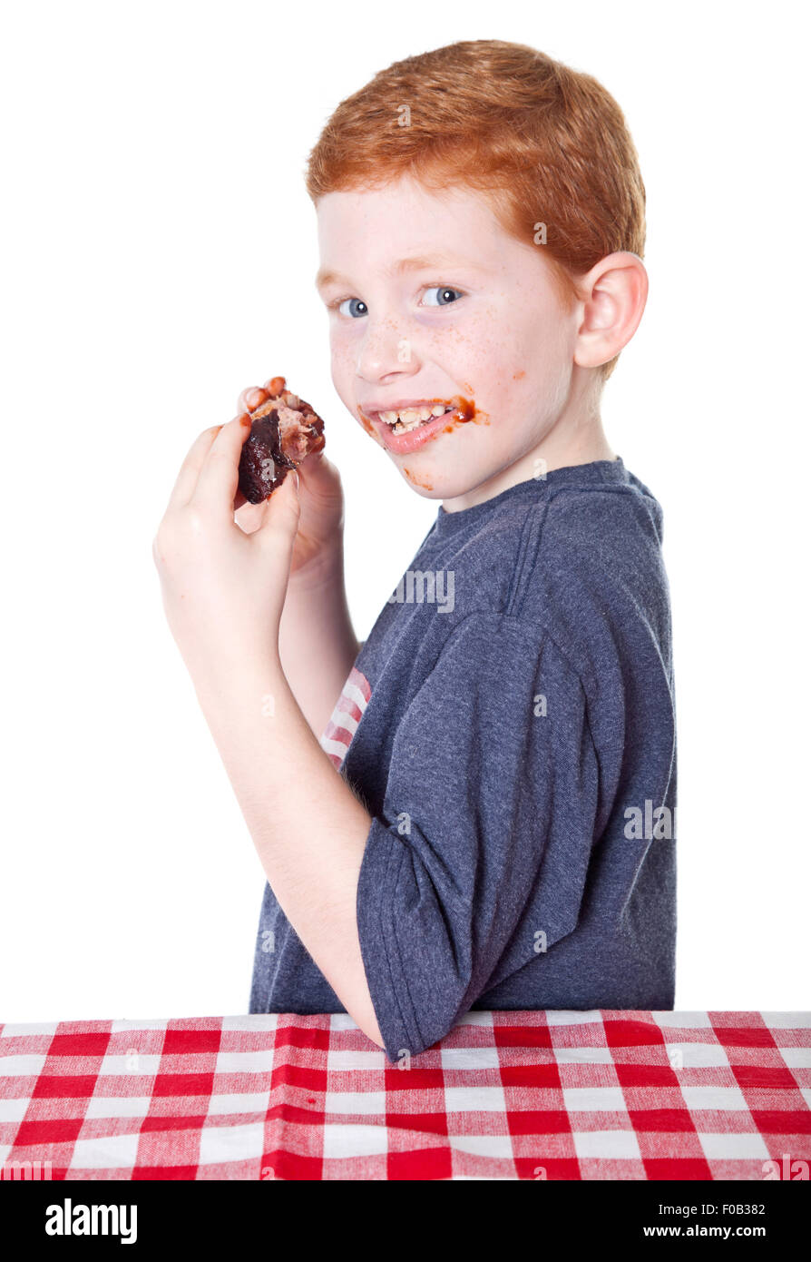 Hungry boy eating BBQ rib in studio Stock Photo - Alamy