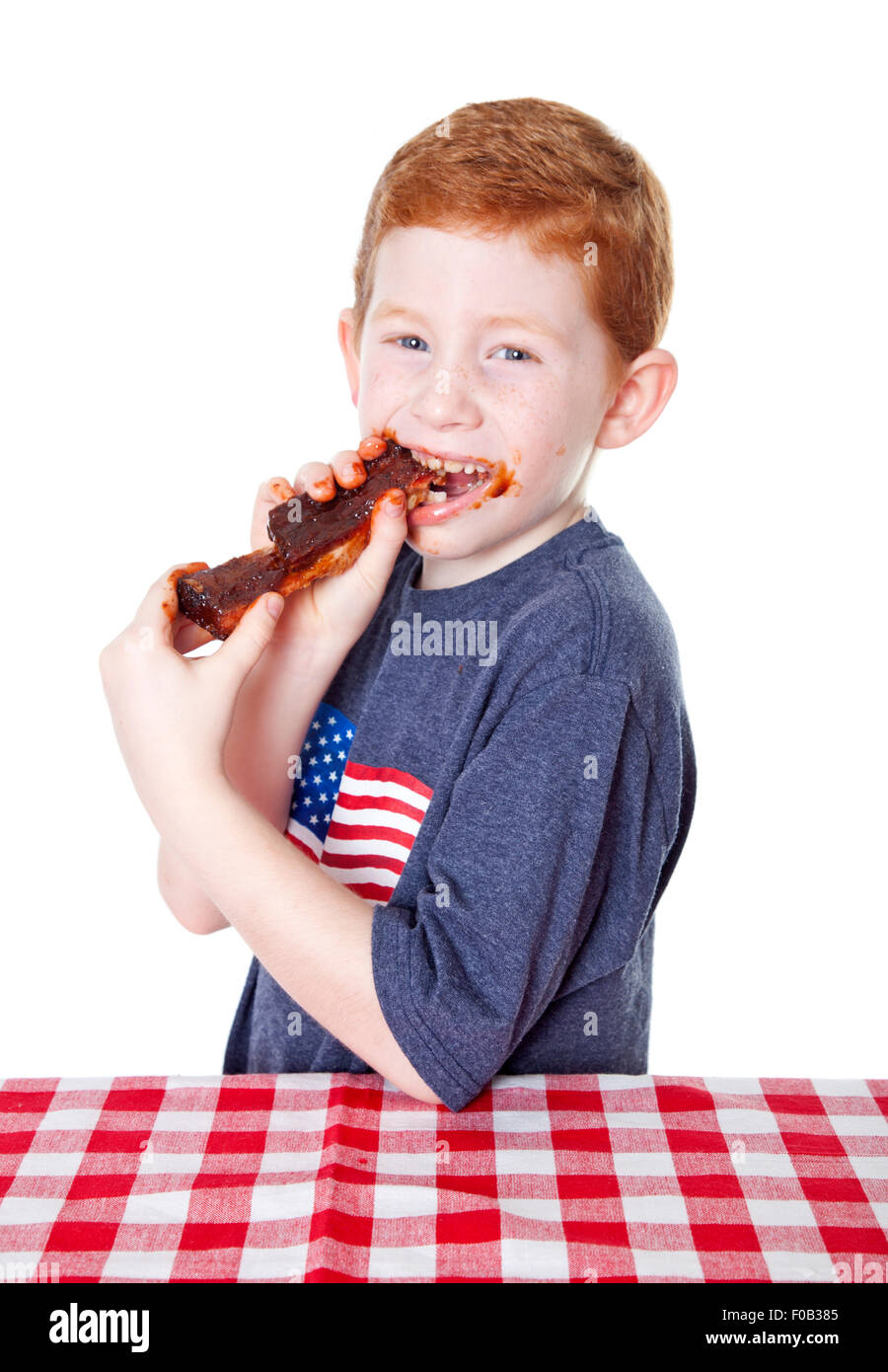 Hungry boy eating BBQ rib in studio Stock Photo - Alamy