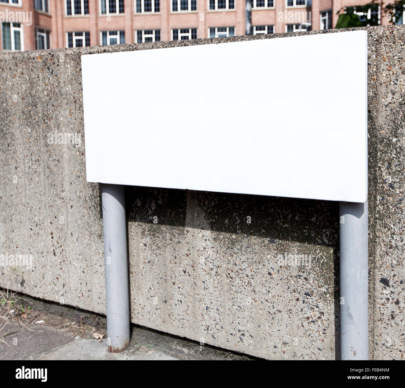 Blank street sign against a concrete wall Stock Photo - Alamy