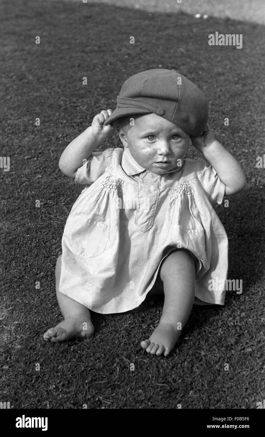 A toddler putting an adult's hat on her head Stock Photo - Alamy
