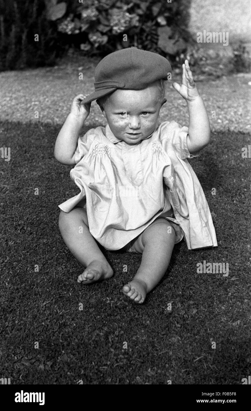 A toddler putting an adult's hat on her head Stock Photo - Alamy