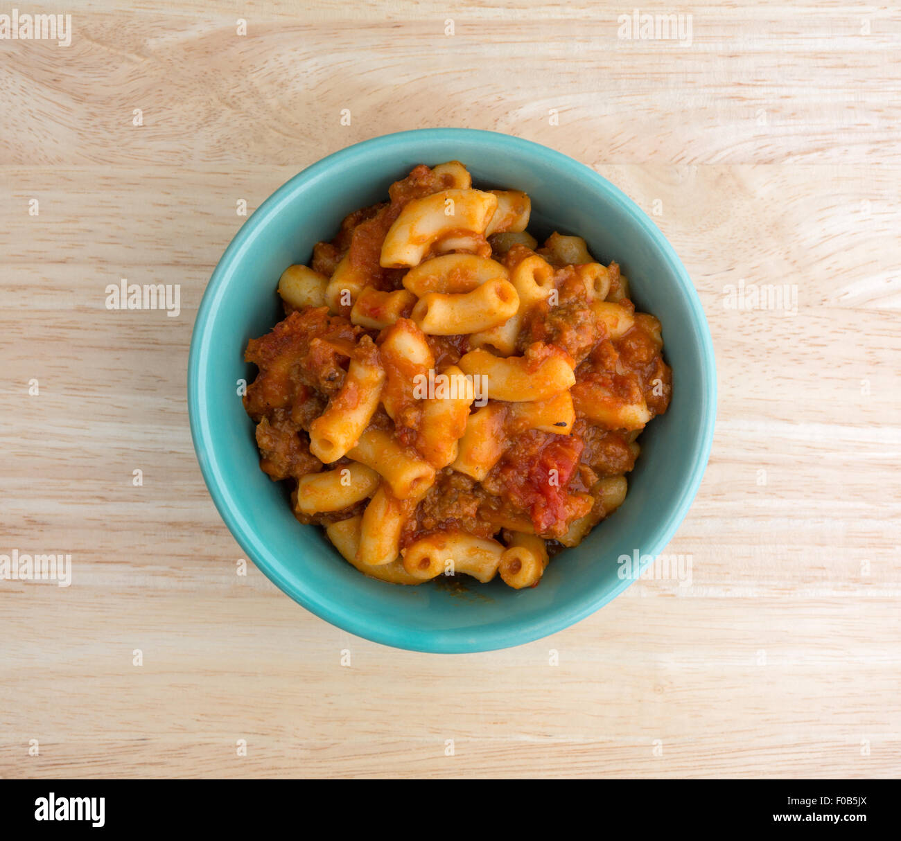 Top view of a small serving of beef and macaroni on a wood table top ...