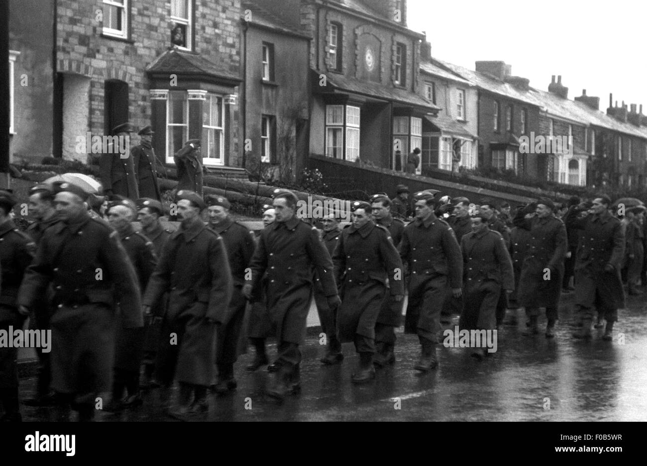 Men of the Home Guard in uniform marching down a residential street in ...