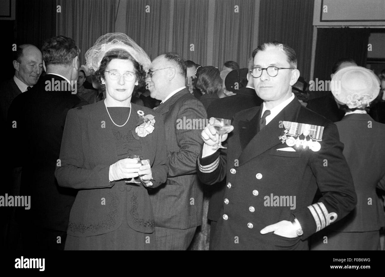 A smartly dressed woman and a man in Royal Navy Officer uniform with ...