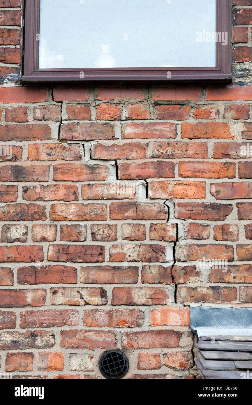step cracking damage to brickwork in a wall beneath a window as a ...