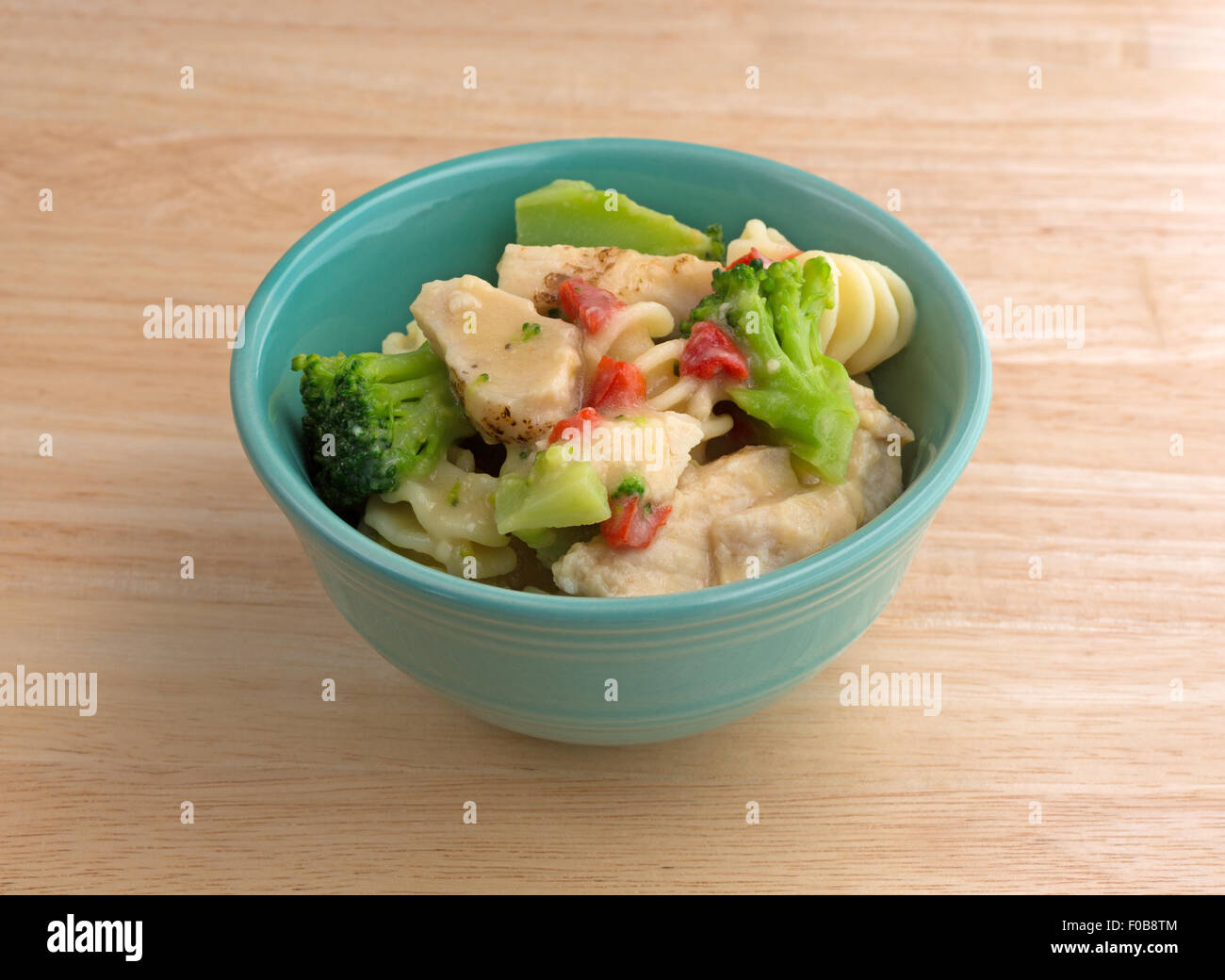 A small bowl with a serving of grilled chicken chunks and assorted ...