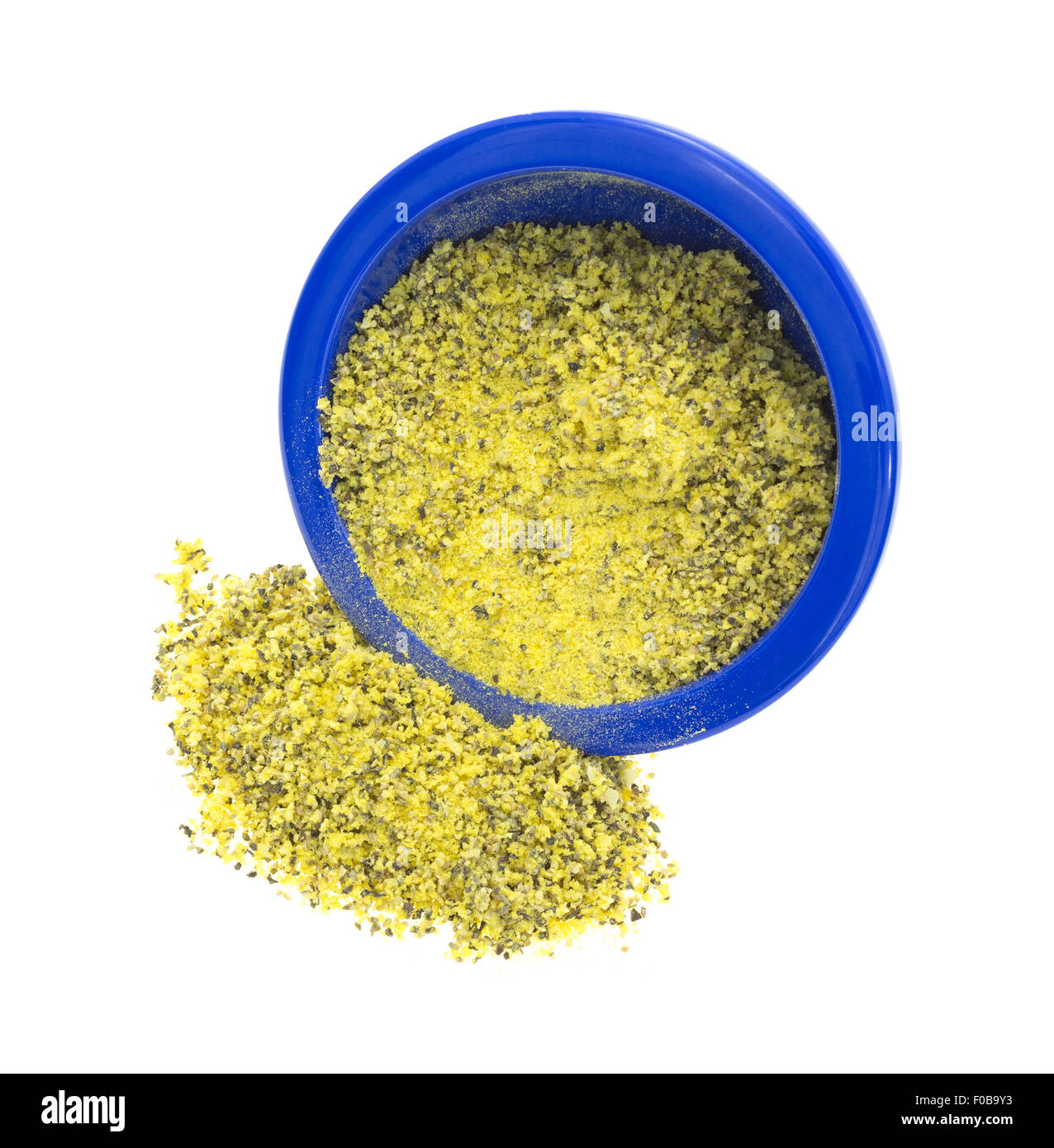 A small blue bowl with lemon pepper seasoning spilling onto a white ...