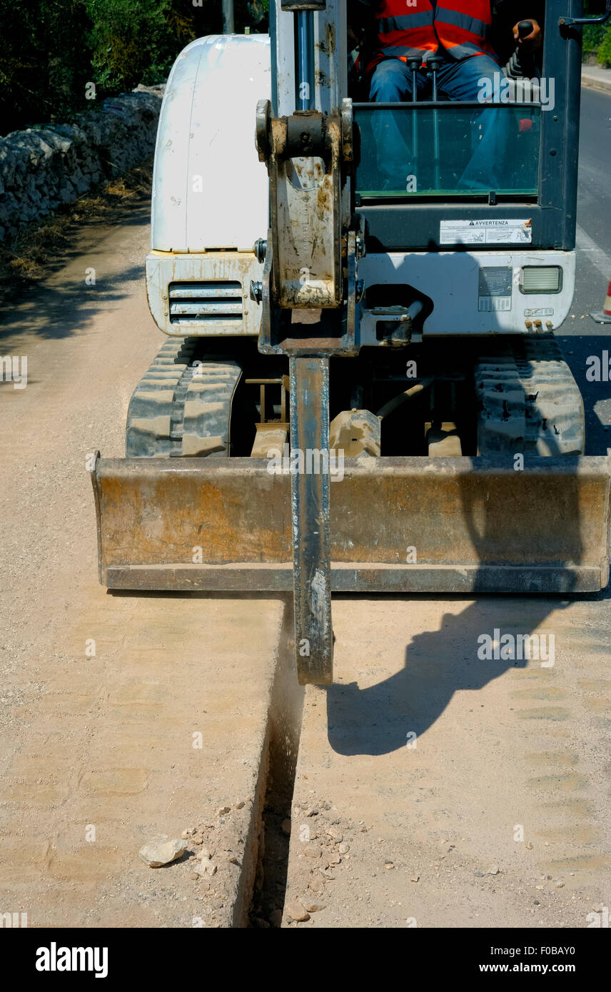 Mini excavator dig a trench with a bucket micro very tight Stock Photo ...