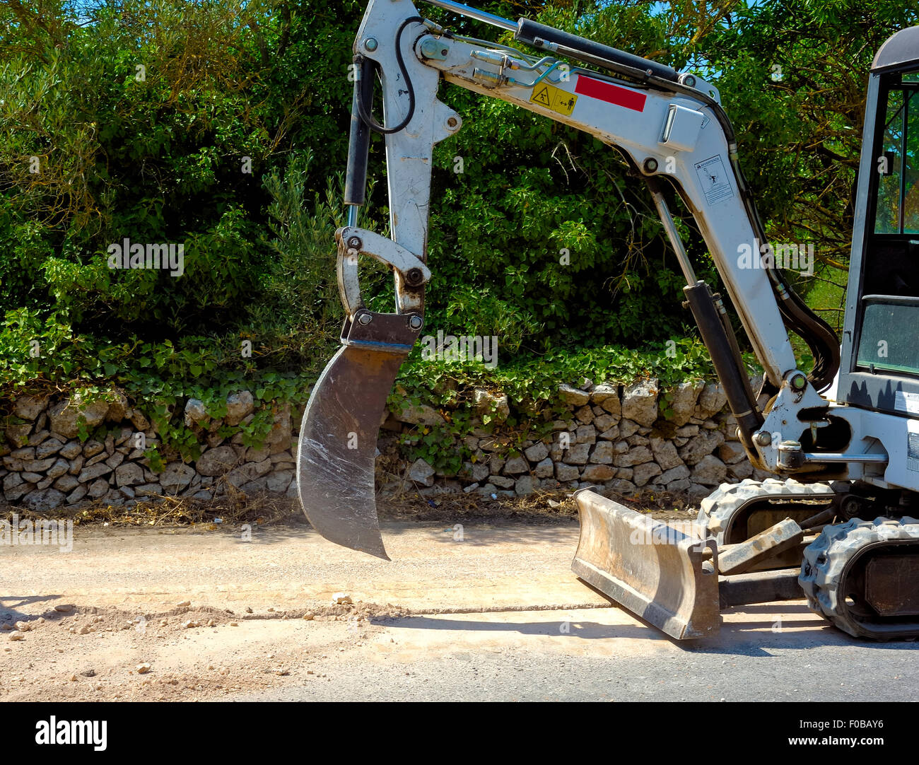 Mini excavator dig a trench with a bucket micro very tight Stock Photo ...
