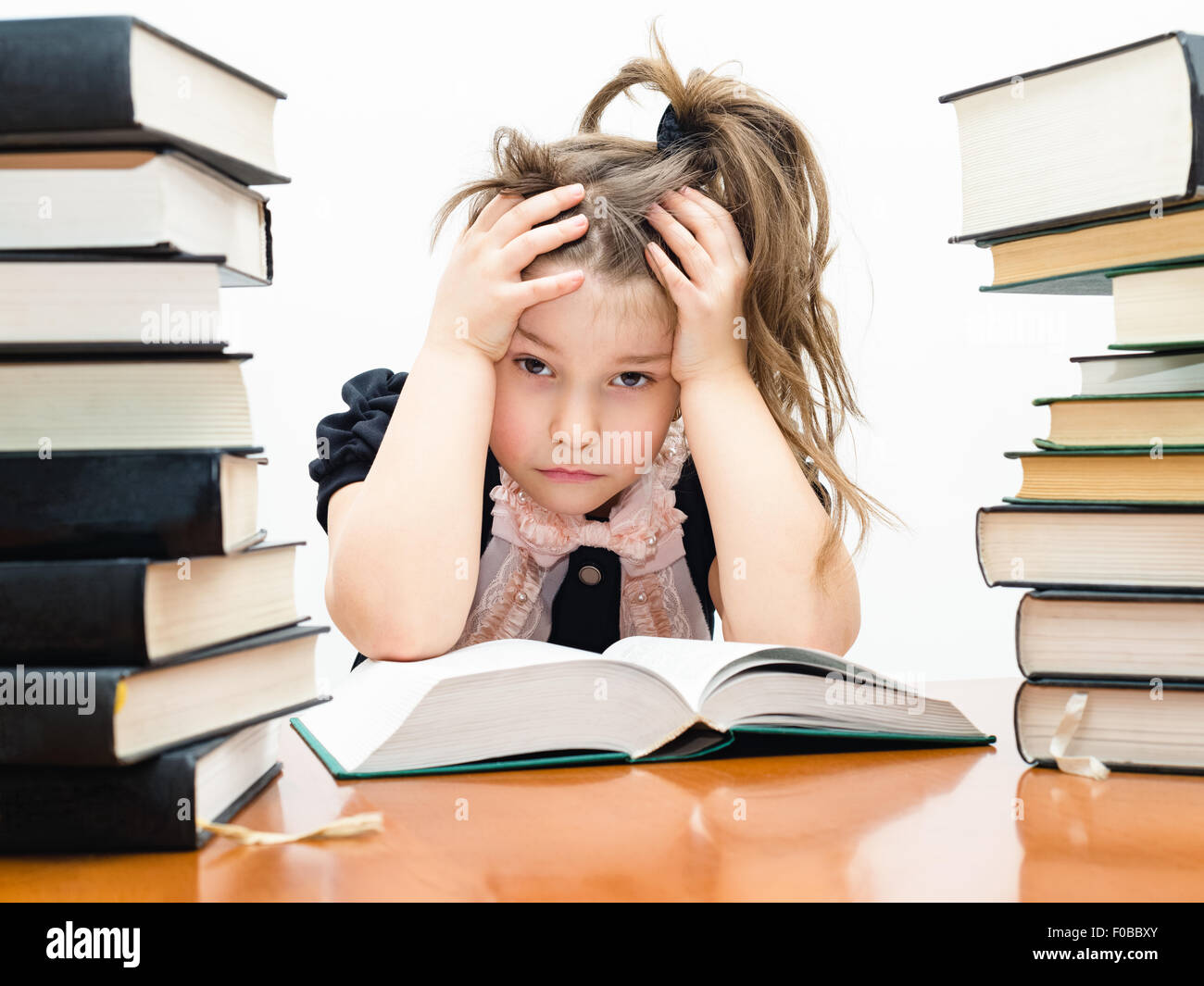Portrait of a tired little girl among books Stock Photo - Alamy