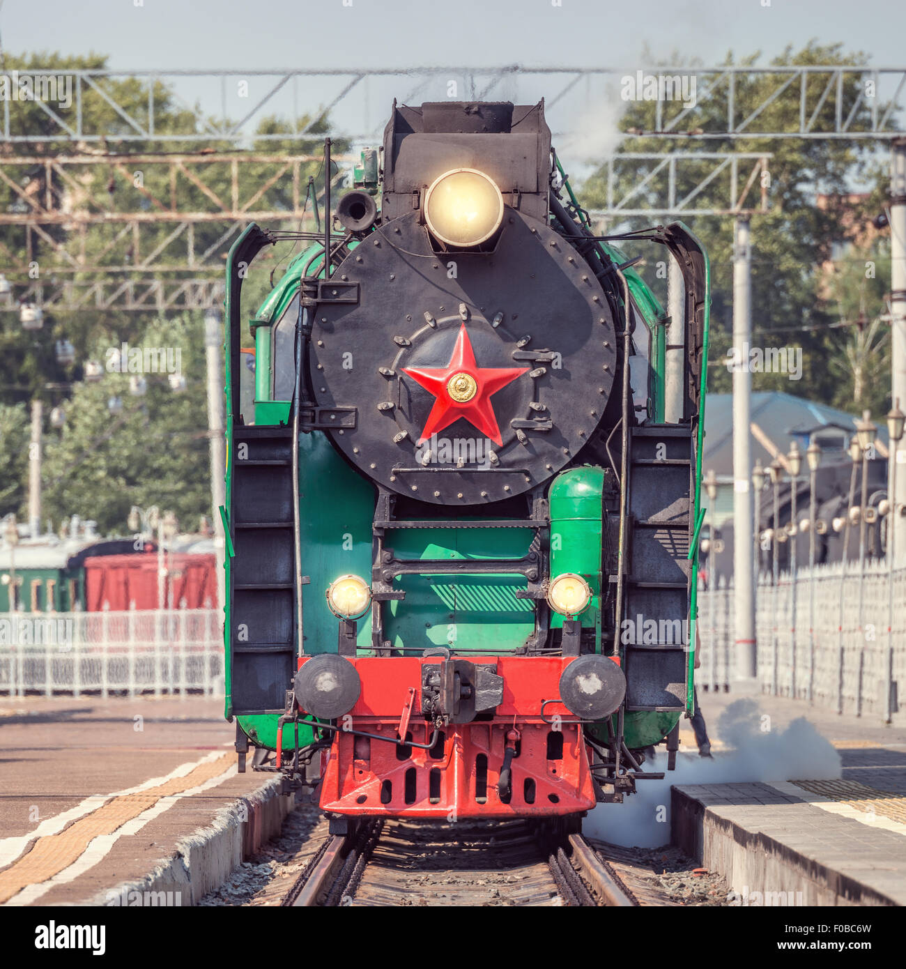 Retro steam train arrives to the station Stock Photo - Alamy