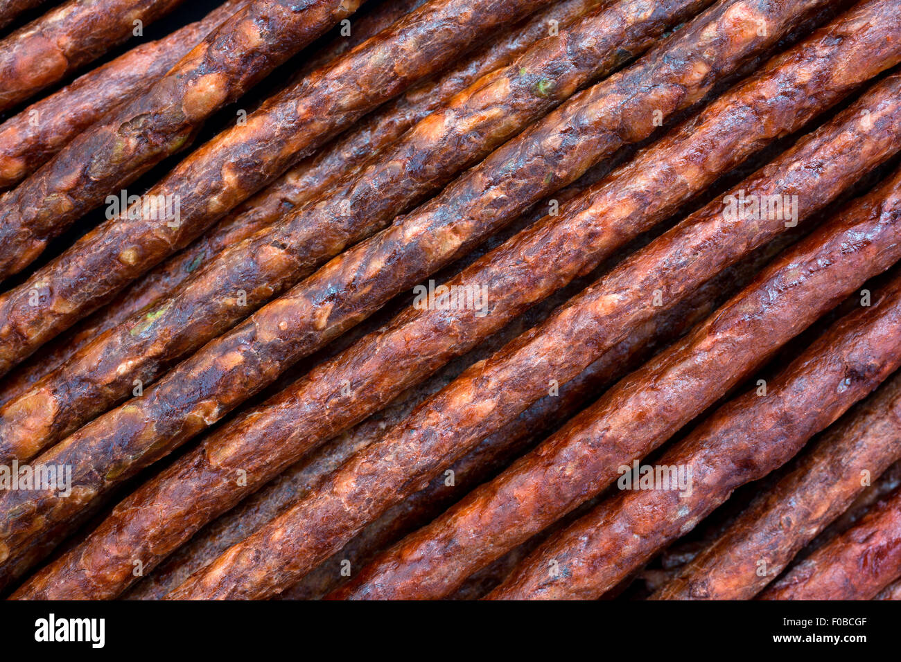 Several rows of rolled rawhide dog chew food Stock Photo - Alamy