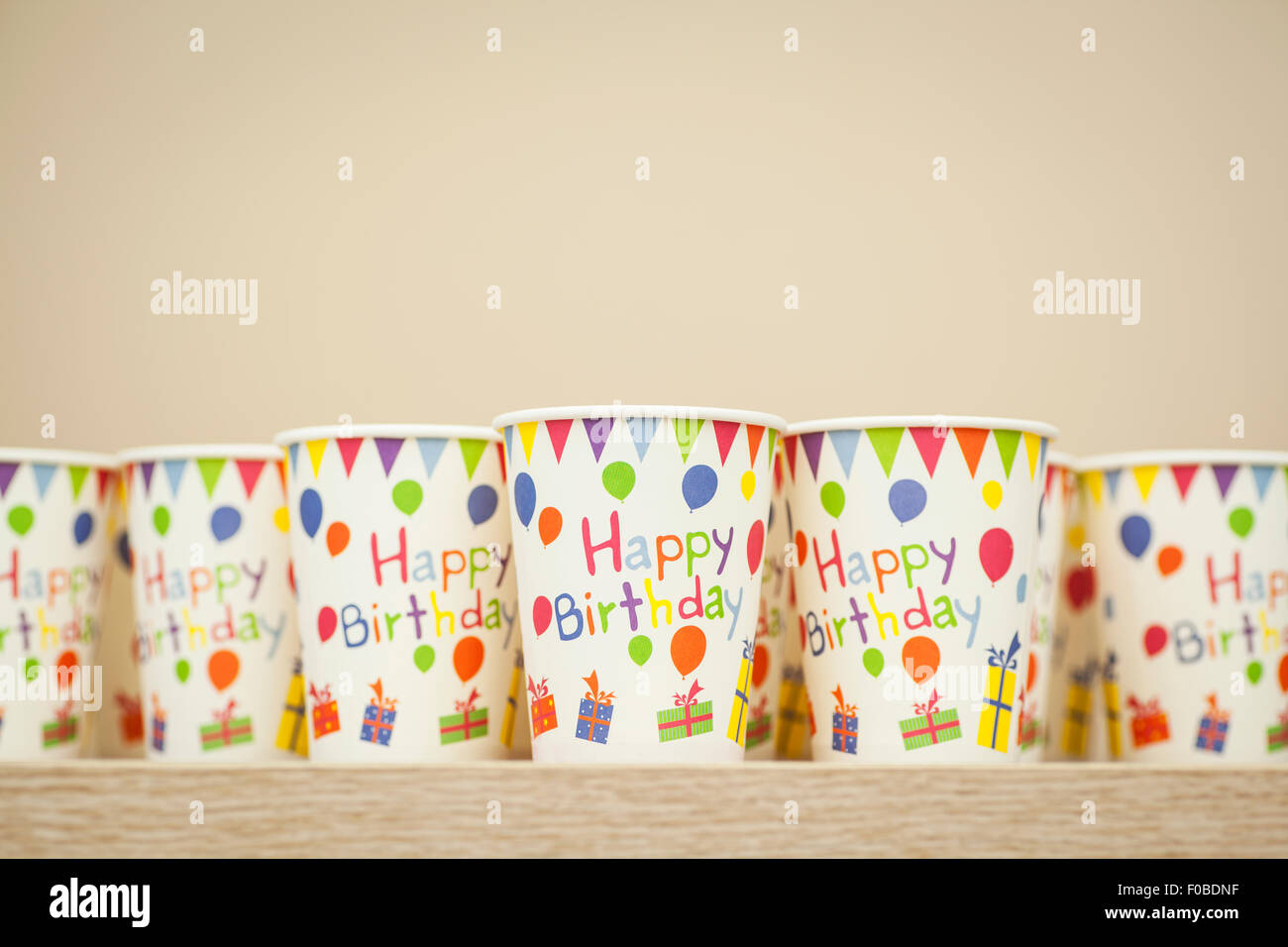 Collection of Happy Birthday paper cups sat on an antique pine wooden ...