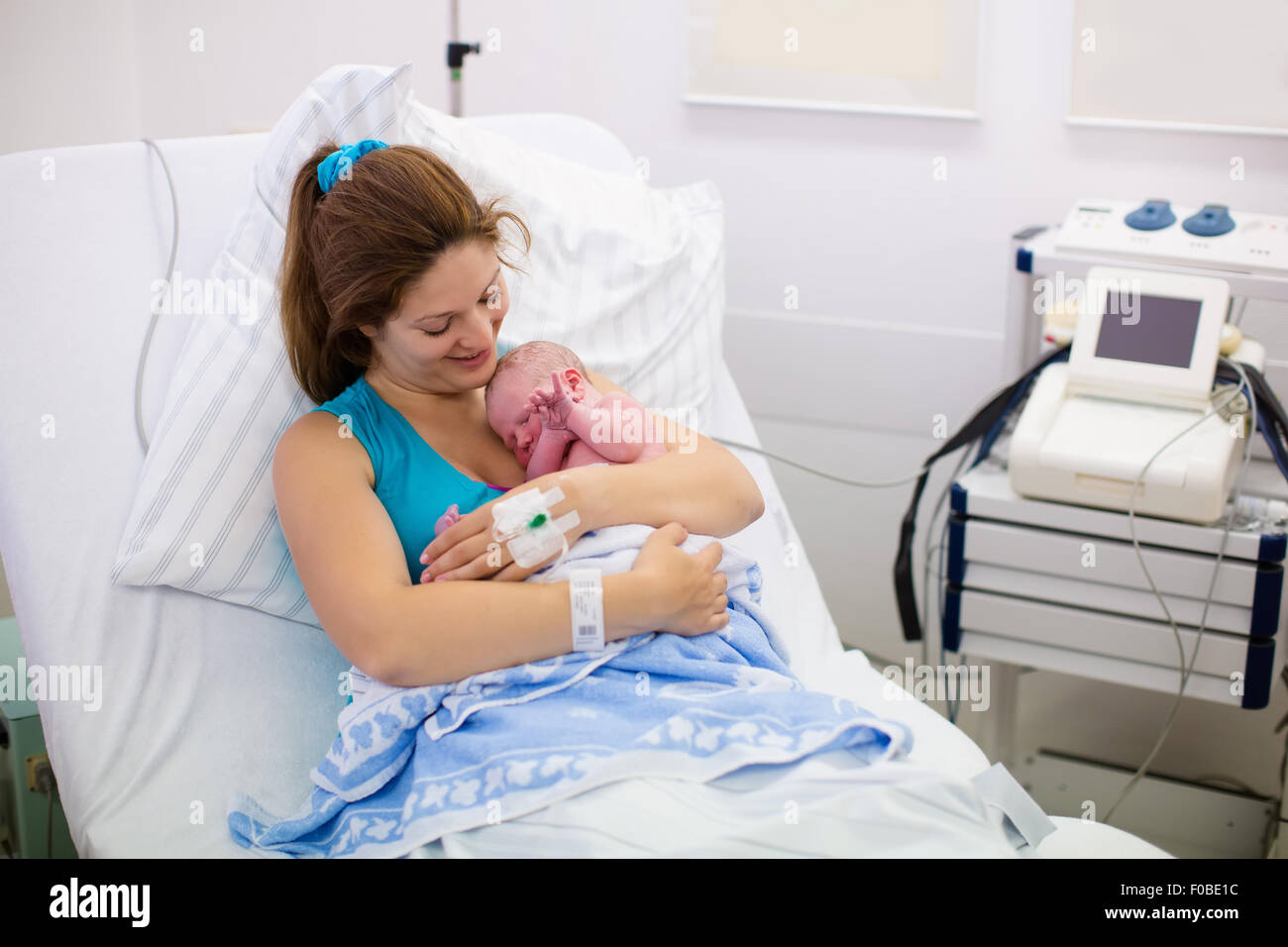 Mother giving birth to a baby. Newborn baby in delivery room. Mom ...