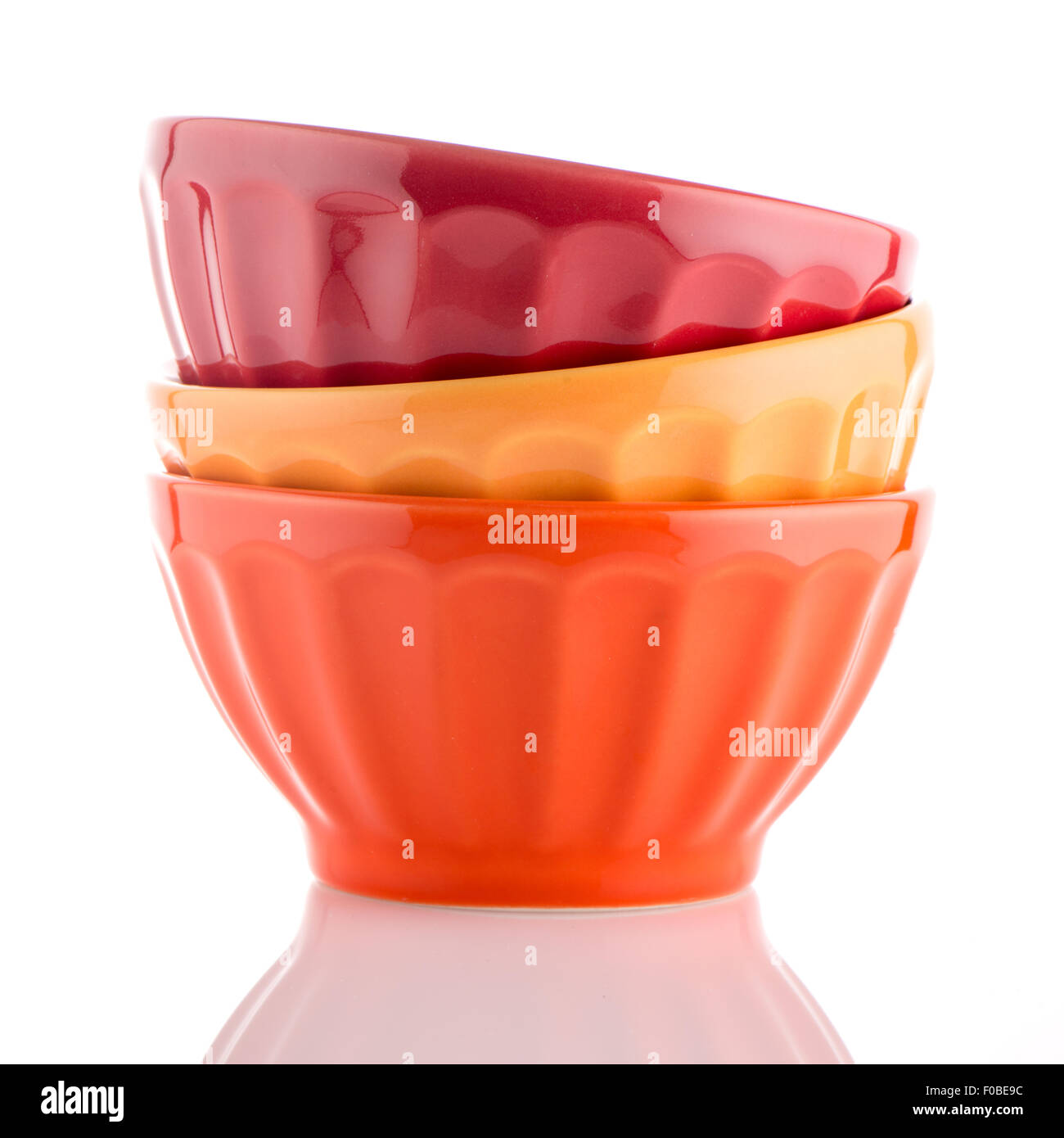 Three colored bowls on white reflective background Stock Photo - Alamy