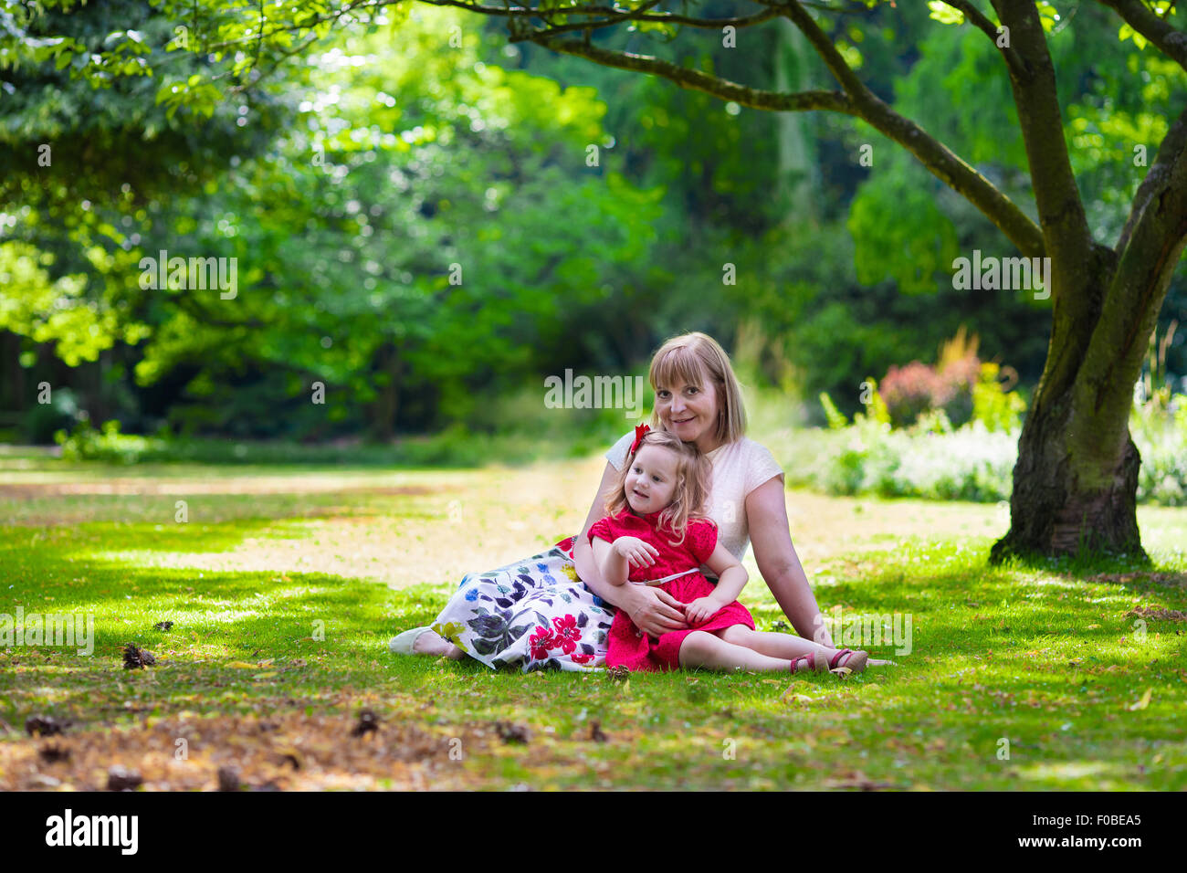 Grandmother and grandchildren enjoying picnic in a park. Grandma ...