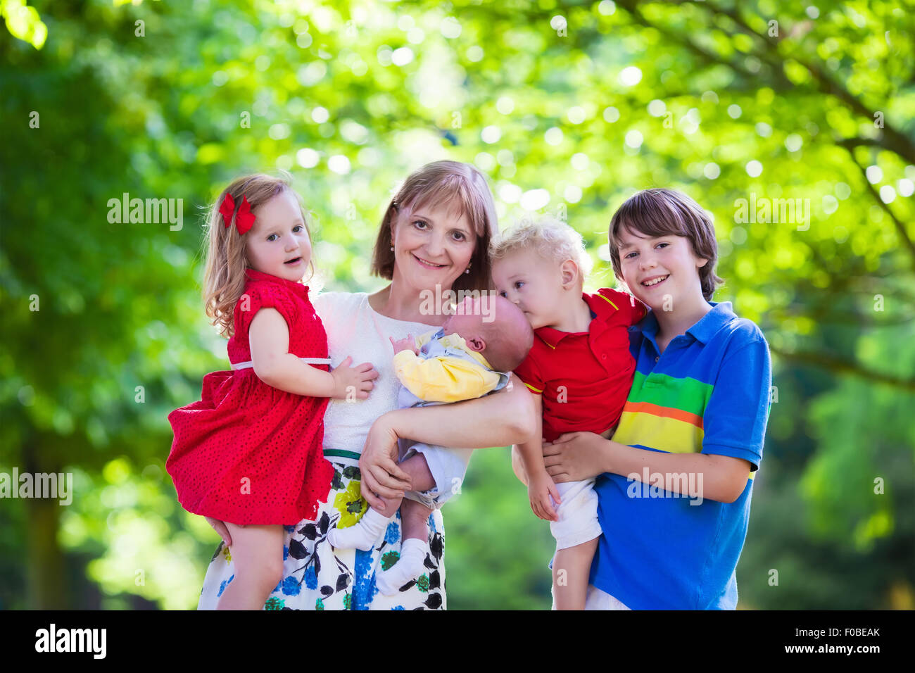 Grandmother and grandchildren enjoying picnic in a park. Grandma ...