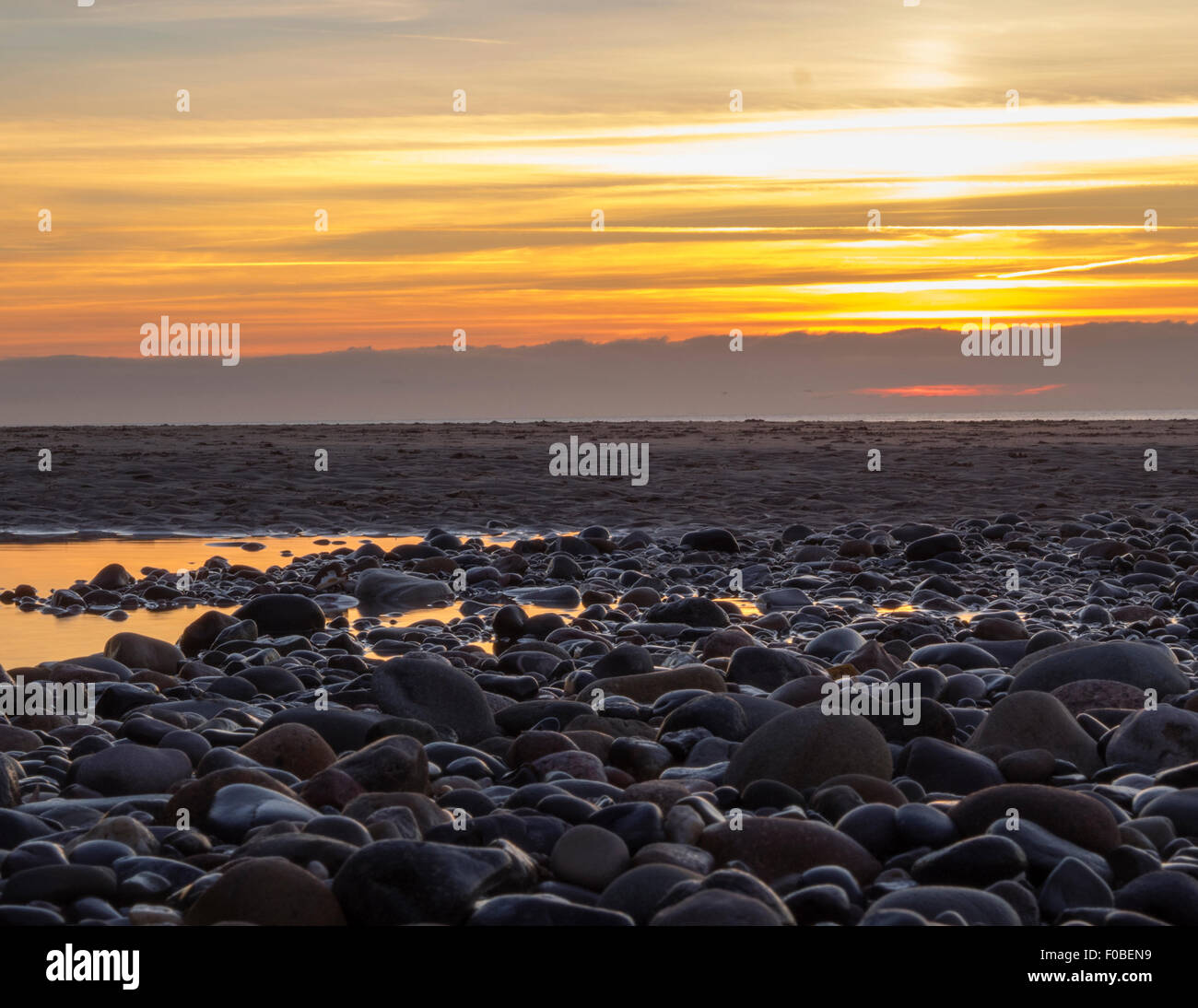 Pebble beach at sunset Stock Photo - Alamy