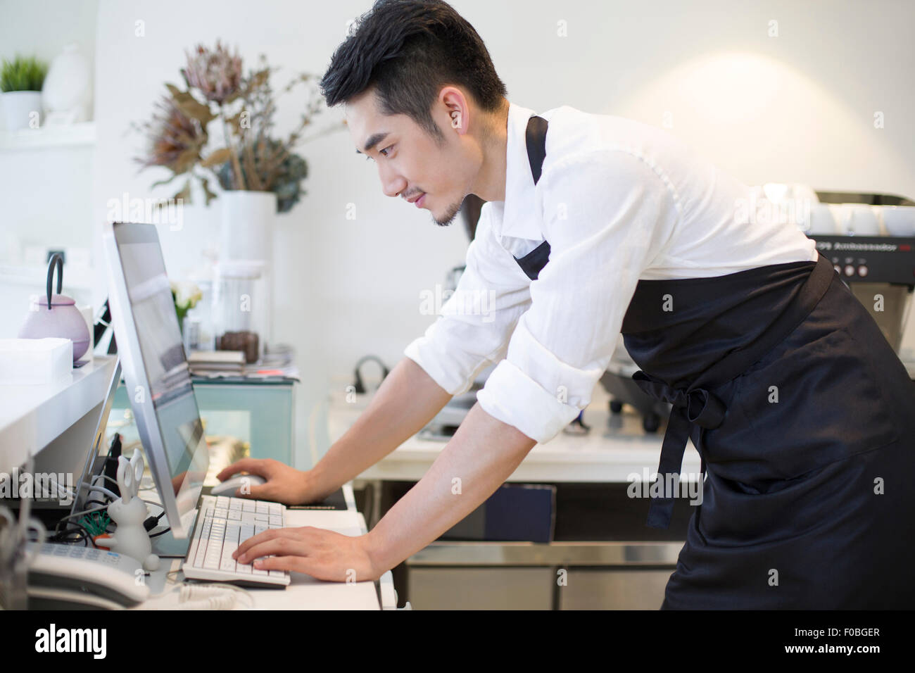 Coffee shop owner using computer Stock Photo - Alamy