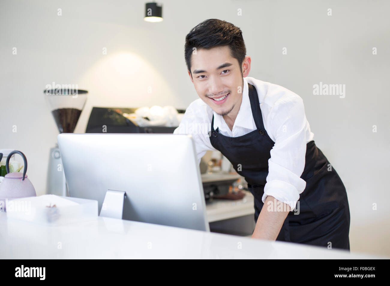 Coffee shop owner using computer Stock Photo - Alamy