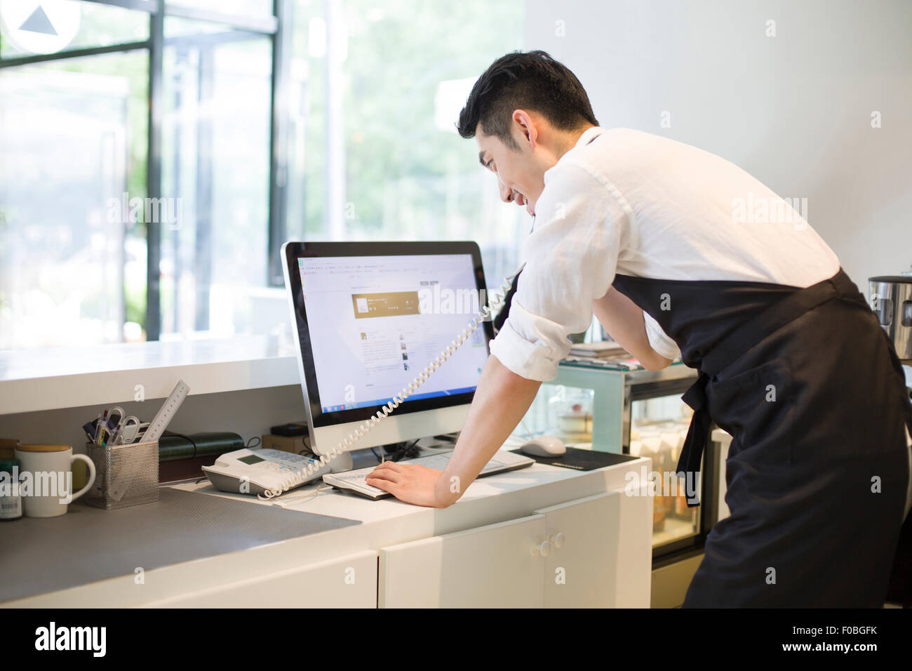 Standing smiling looking away holding landline phone communication ...