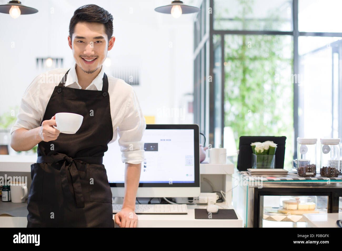Coffee shop owner drinking coffee Stock Photo - Alamy