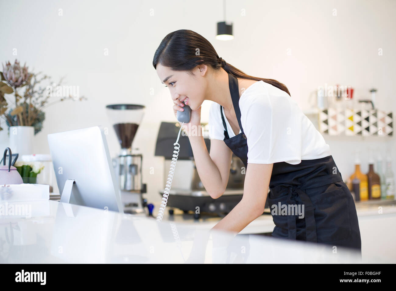 Coffee shop owner talking on the phone Stock Photo - Alamy