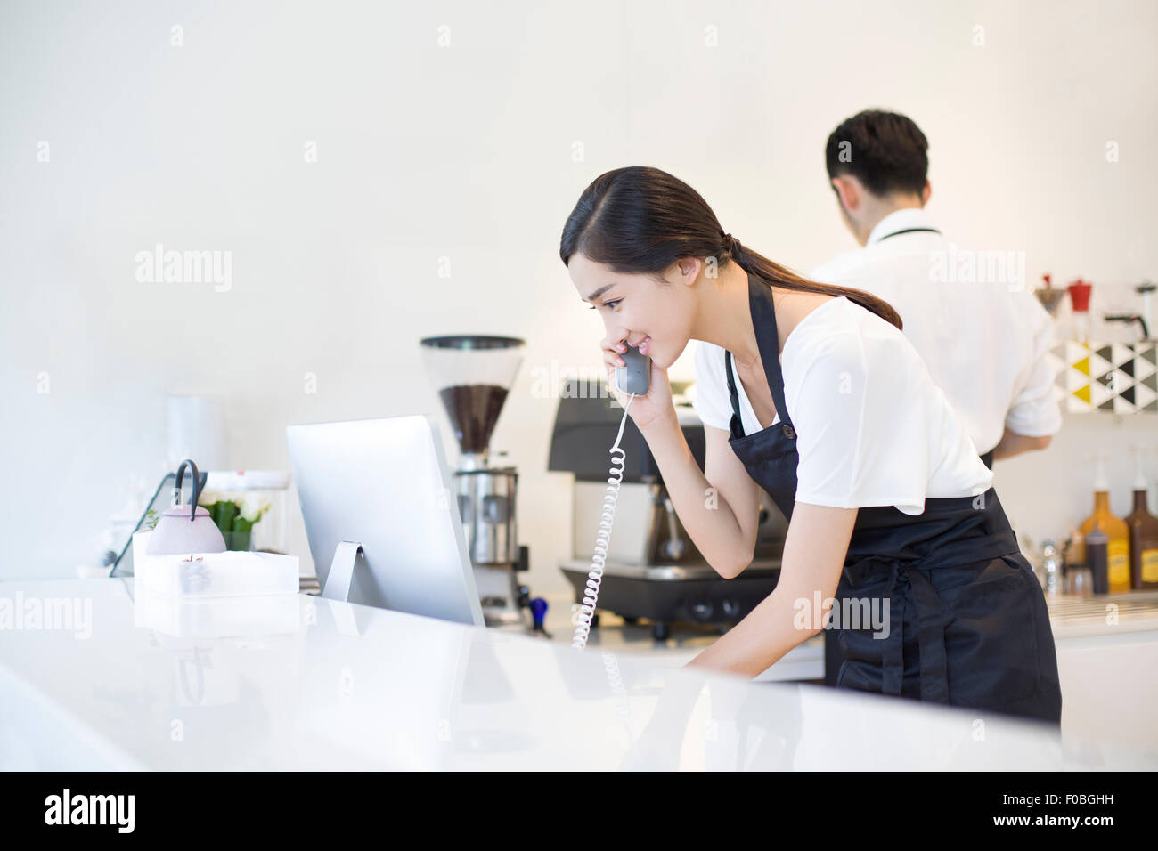 Standing smiling looking away holding landline phone communication ...