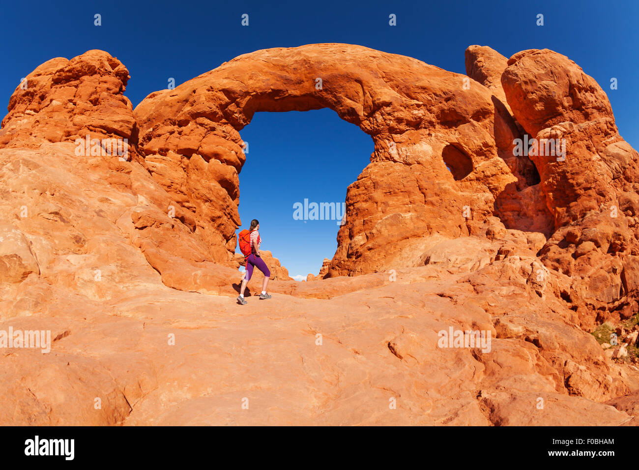 View of girl walking to beautiful arches Utah Stock Photo - Alamy
