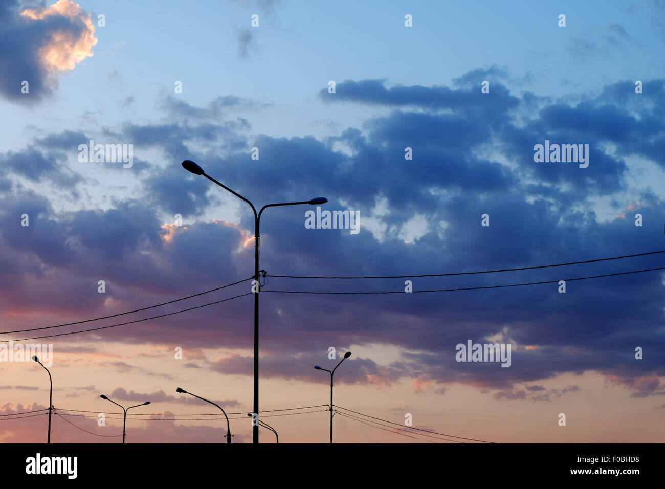 Street lamps over colorful sunset cloudscape Stock Photo - Alamy