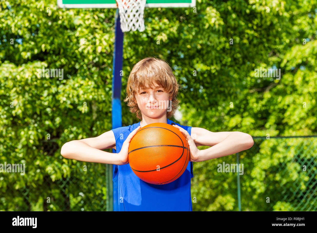 Boy holds ball alone during basketball game Stock Photo - Alamy