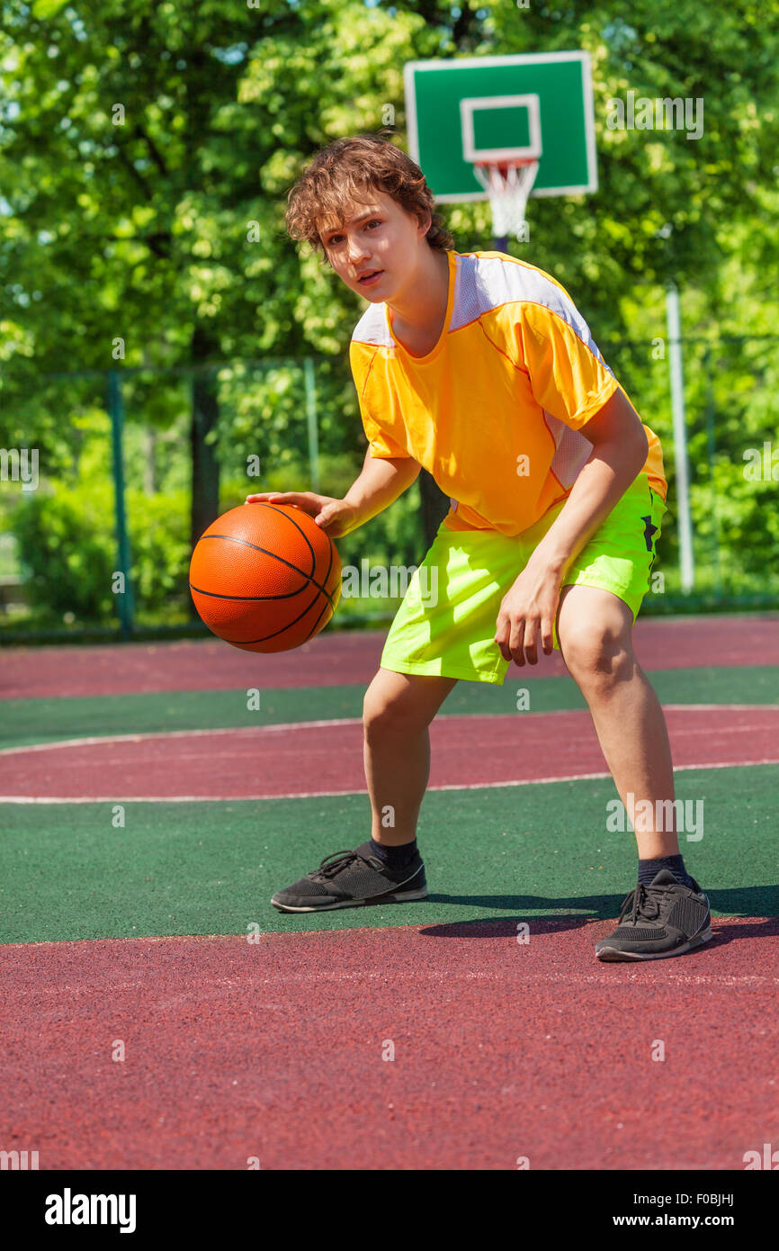 Boy playing with ball alone during basketball game Stock Photo - Alamy