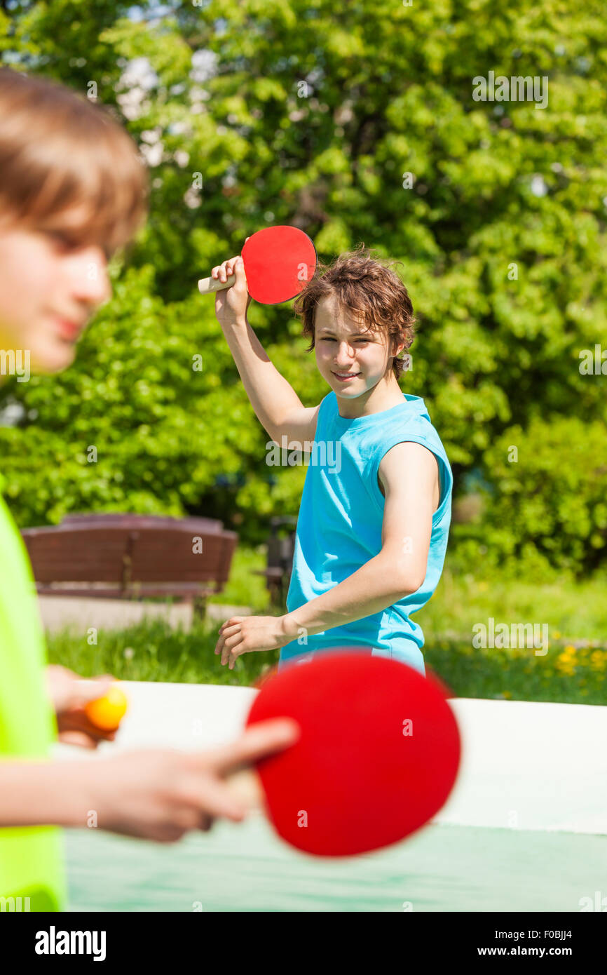 Two smiling friends playing together ping pong Stock Photo - Alamy