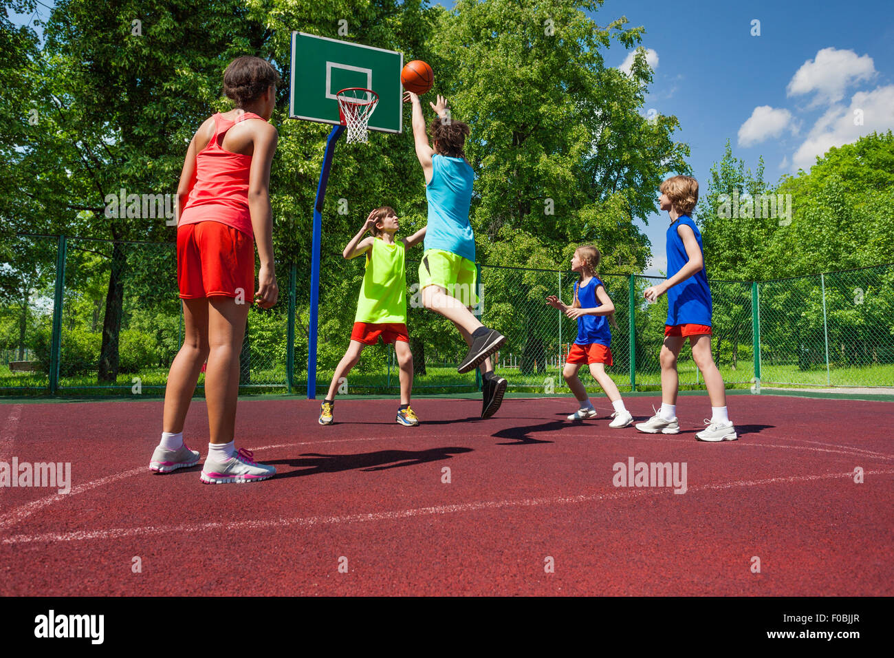 Team in colorful uniforms playing basketball game Stock Photo - Alamy