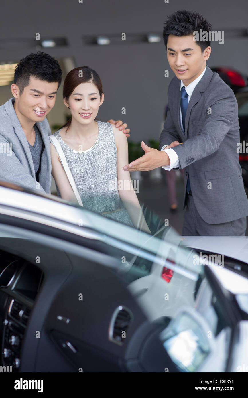 Young couple choosing car in showroom Stock Photo - Alamy