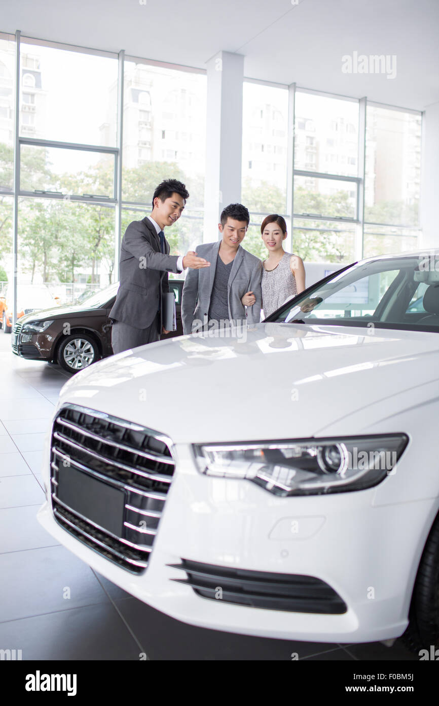 Young couple choosing car in showroom Stock Photo - Alamy