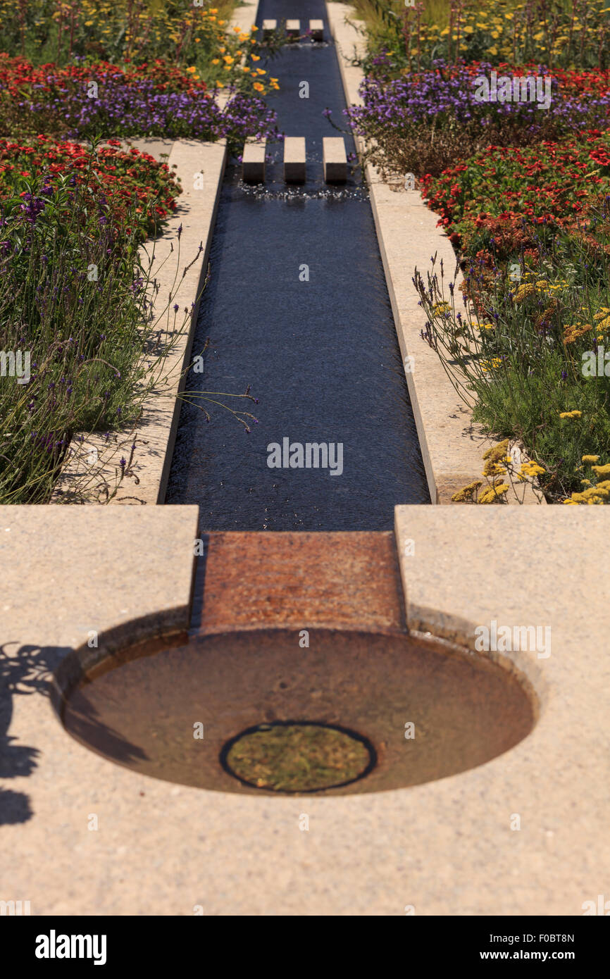 Long fountain that empties into a pond via a waterfall in the middle of ...